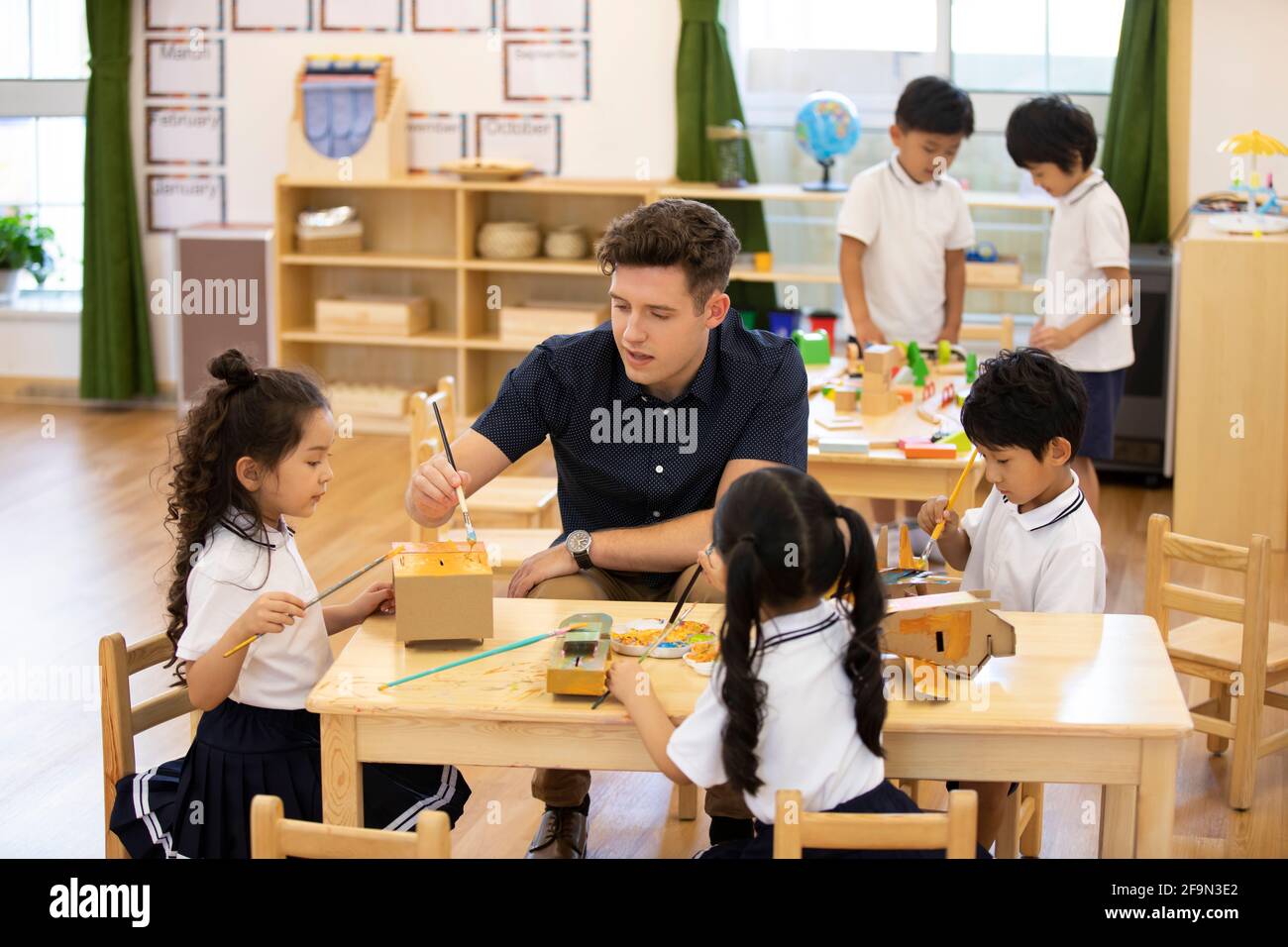 Foreign teacher teaching art class in classroom Stock Photo - Alamy