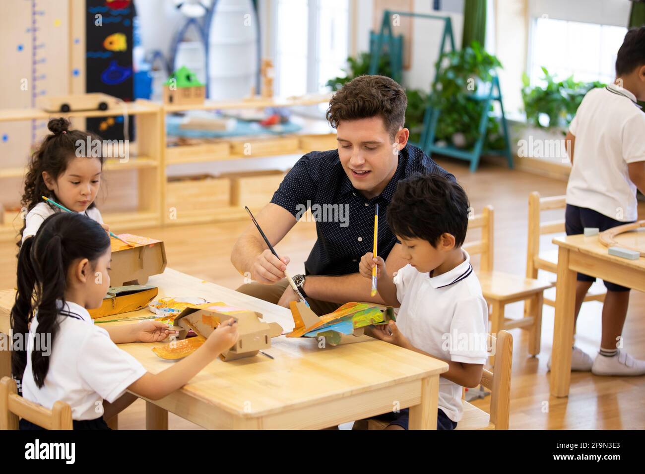 Foreign teacher teaching art class in classroom Stock Photo - Alamy