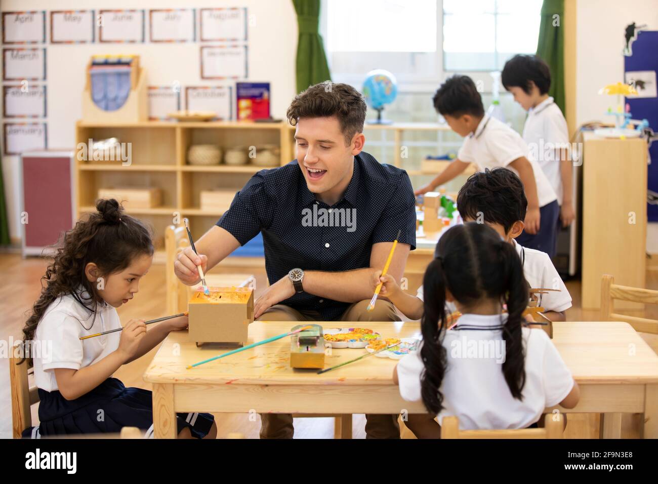 Foreign teacher teaching art class in classroom Stock Photo - Alamy