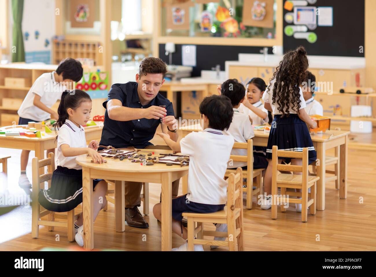Foreign teacher teaching art class in classroom Stock Photo - Alamy
