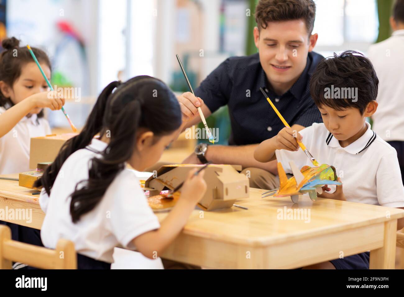Foreign teacher teaching art class in classroom Stock Photo - Alamy
