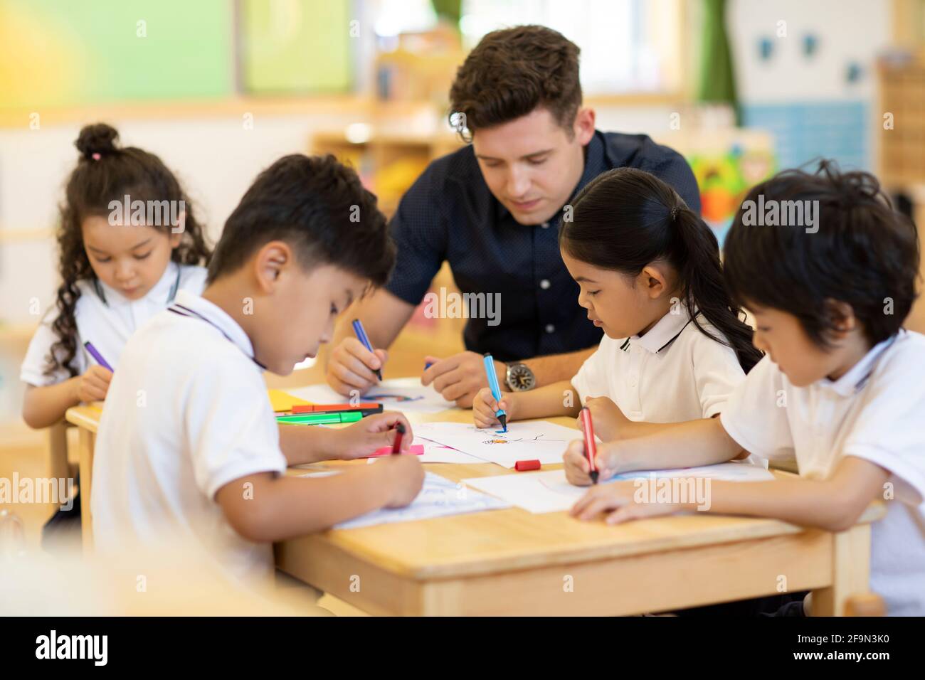 Foreign teacher teaching art class in classroom Stock Photo - Alamy