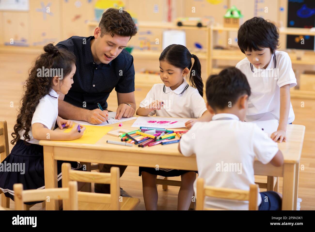 Foreign teacher teaching art class in classroom Stock Photo - Alamy