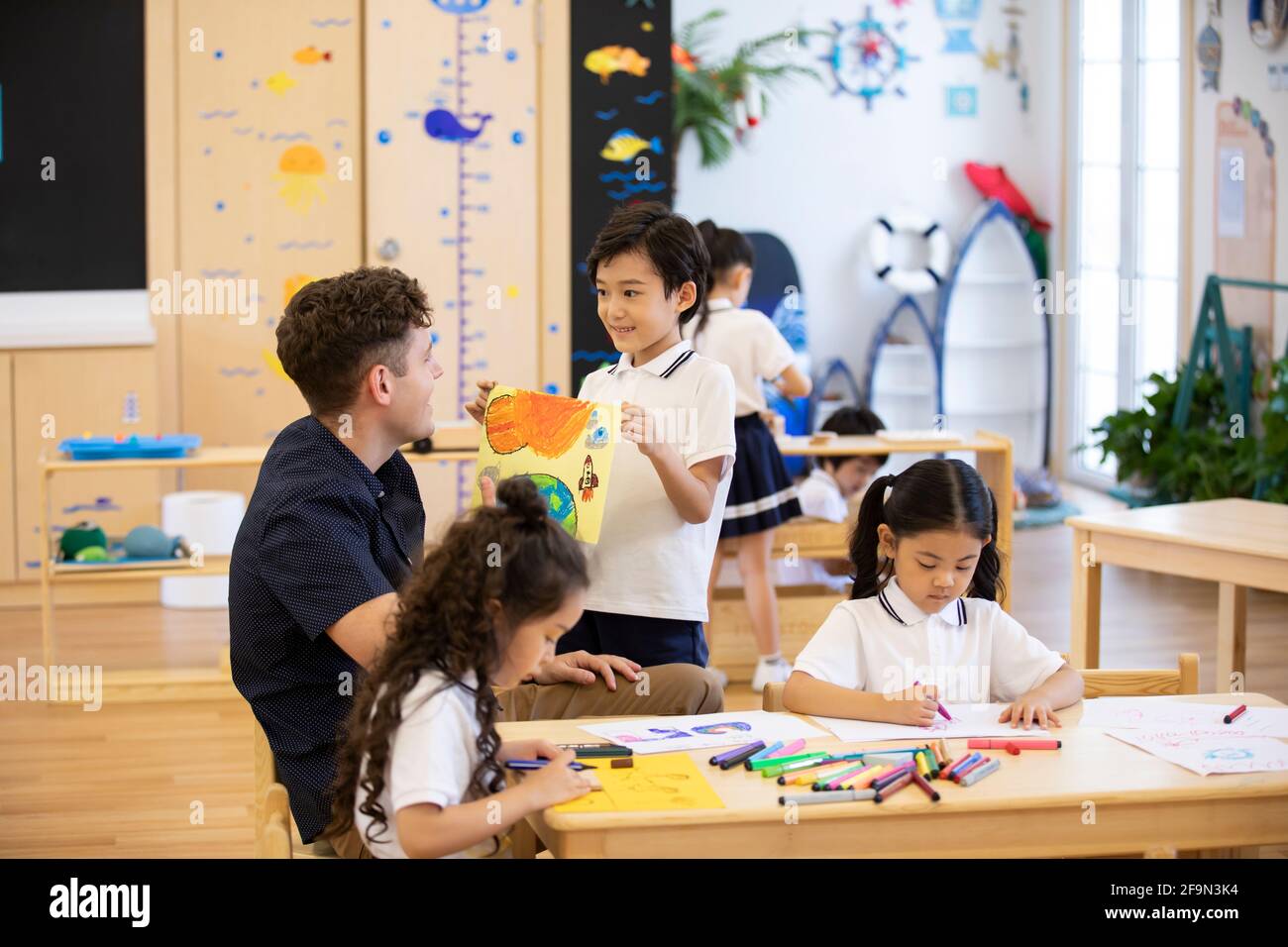 Foreign teacher teaching art class in classroom Stock Photo - Alamy