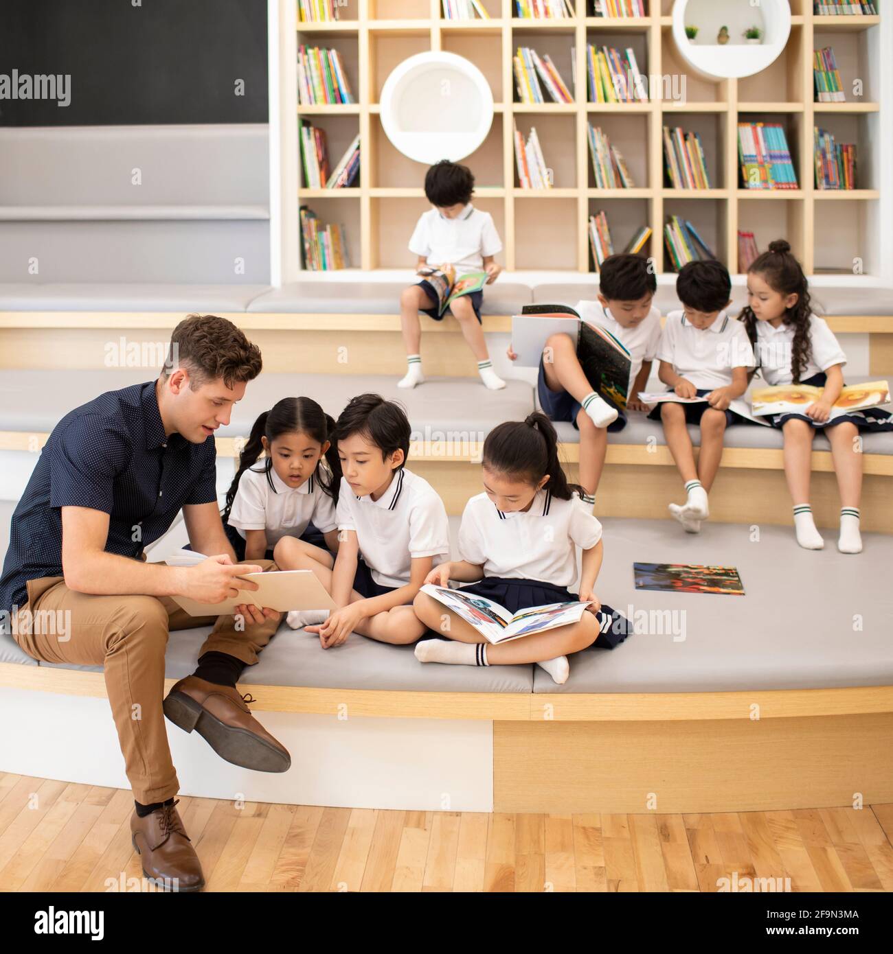 Children reading book in library Stock Photo - Alamy
