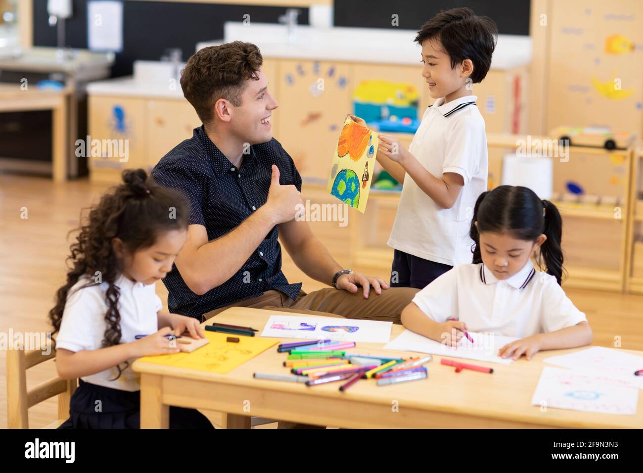 Foreign teacher teaching art class in classroom Stock Photo - Alamy
