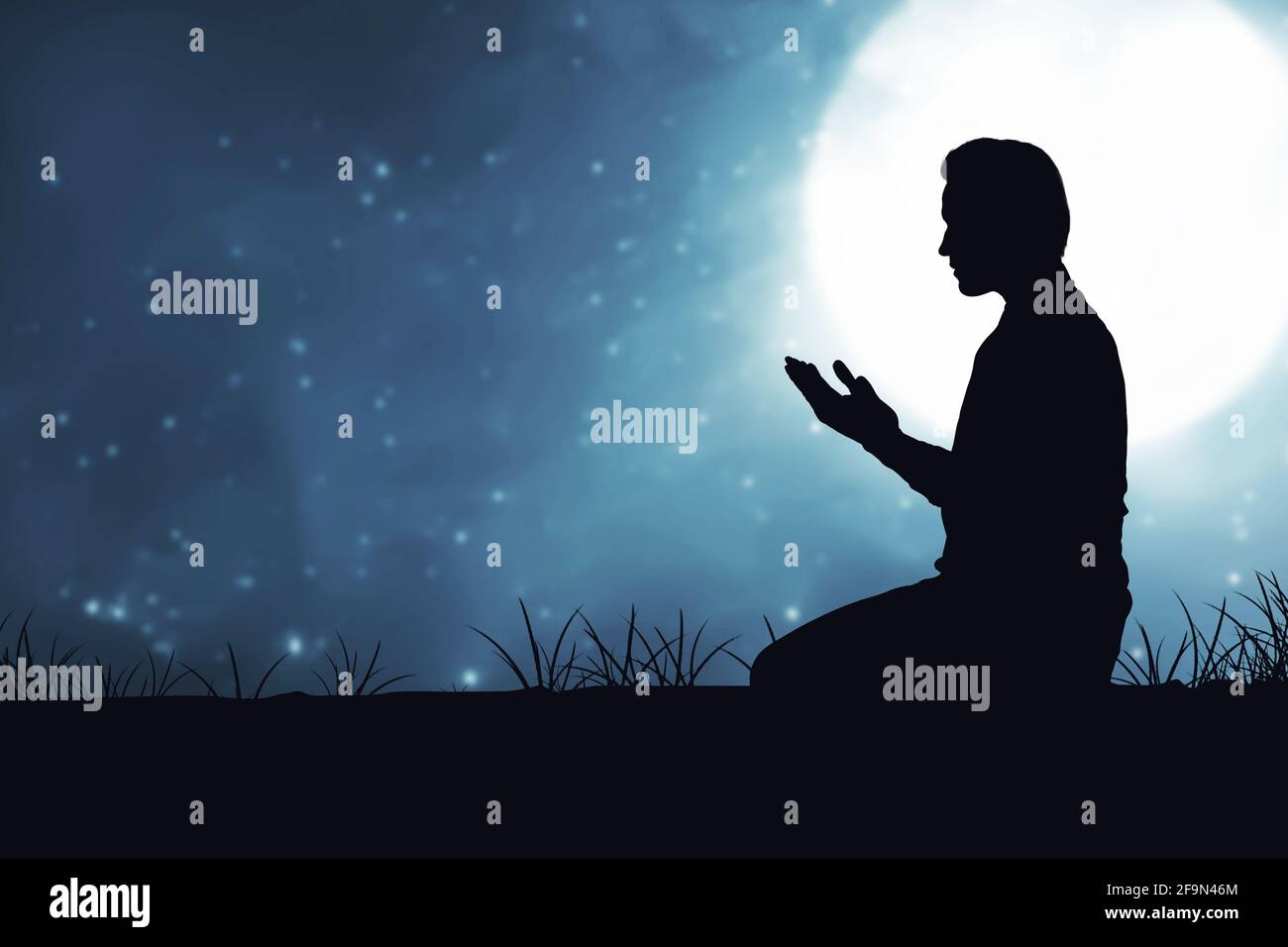 Silhouette of Muslim man sitting while raised hands and praying with ...