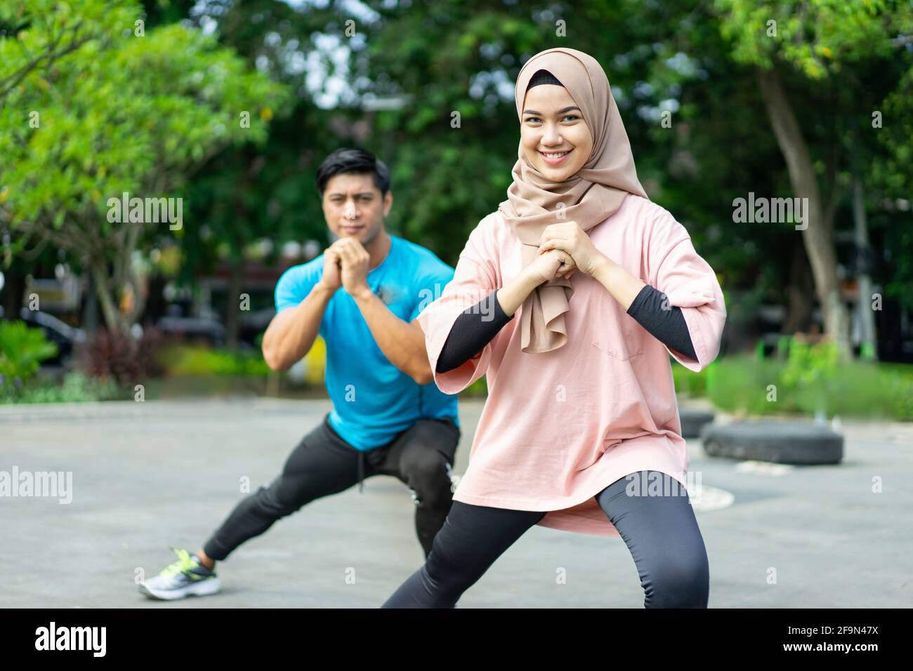 hijab girls doing leg warm-up exercises together Stock Photo - Alamy