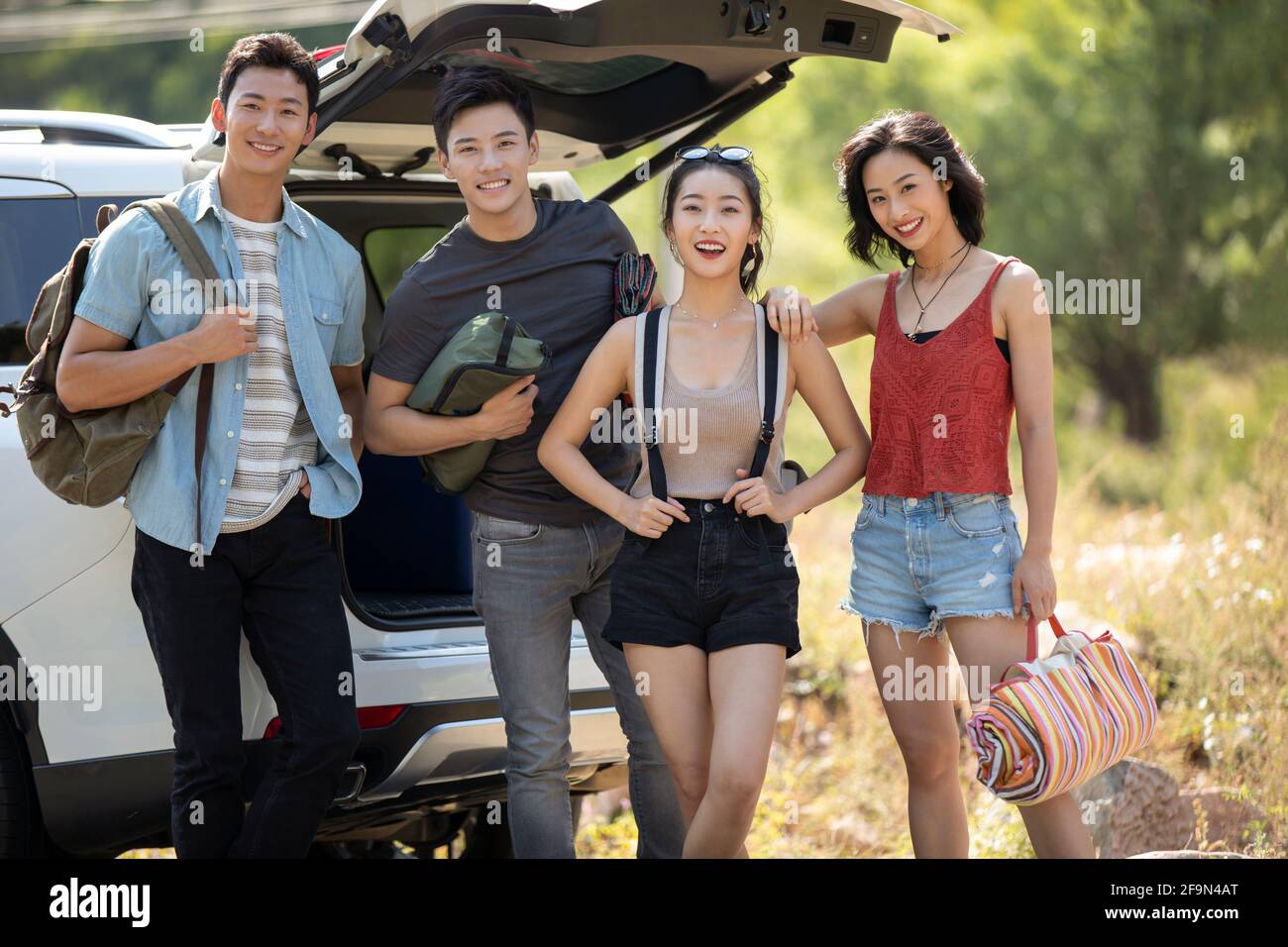 Happy young friends camping outdoors Stock Photo - Alamy