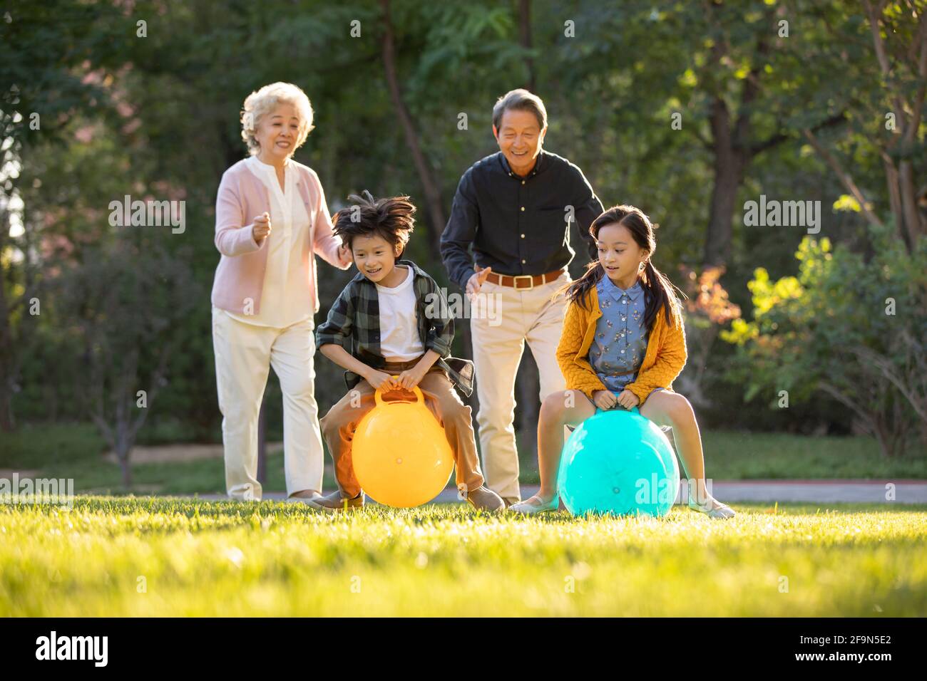 Happy family having fun in park Stock Photo - Alamy