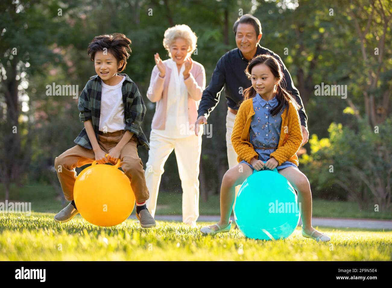 Happy family having fun in park Stock Photo - Alamy