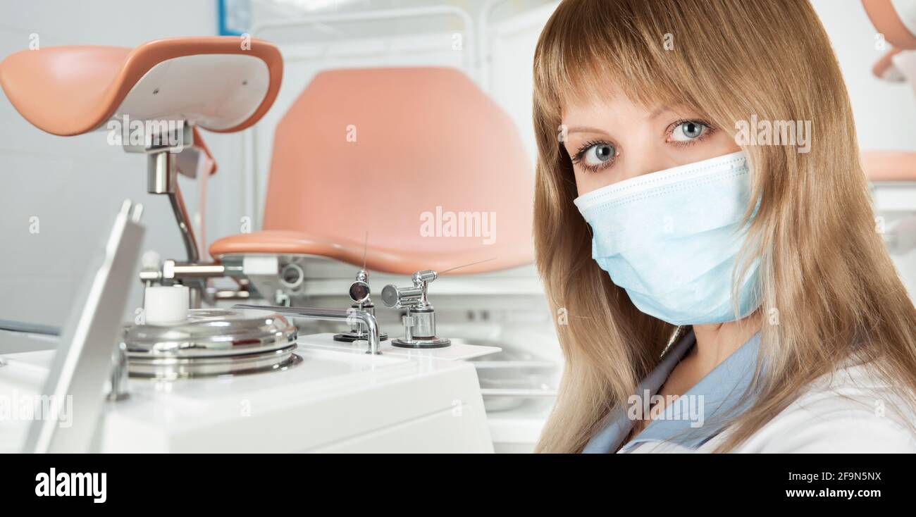 Female gynecologist in protective mask and whitecoat with gynecological ...