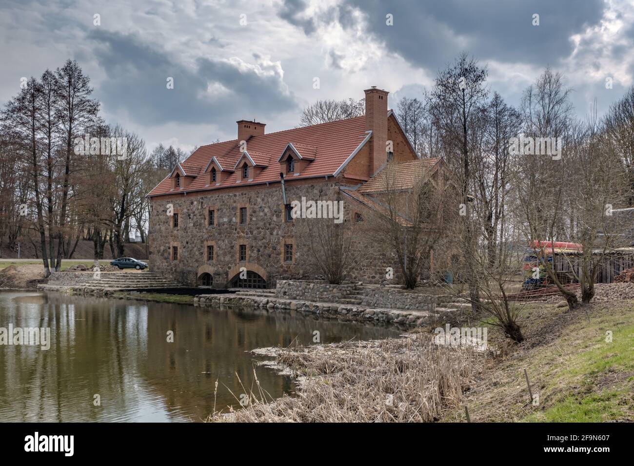 the building of the restored old stone mill in early spring near lake ...