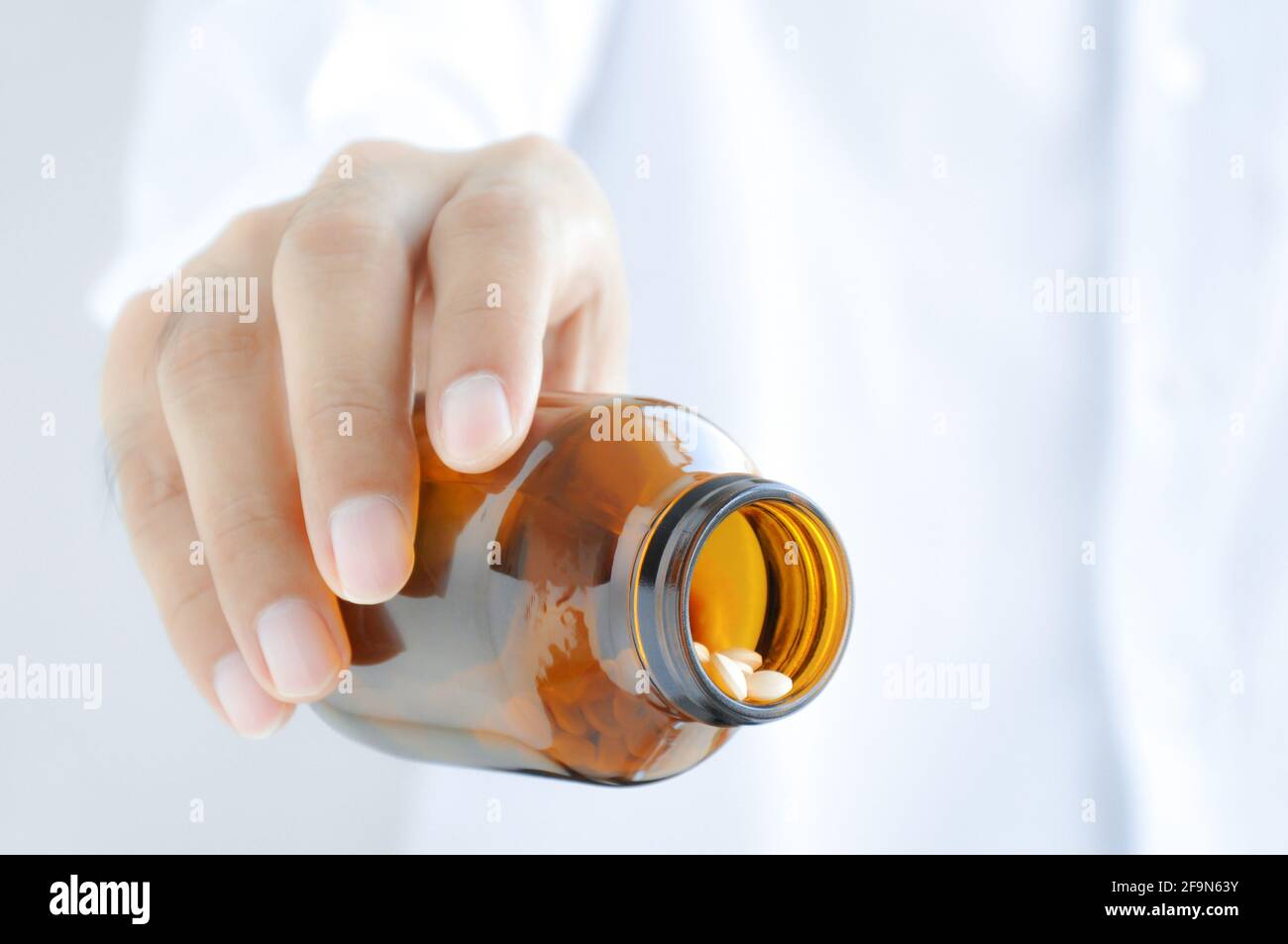 Hand pouring medicines from the bottle Stock Photo - Alamy