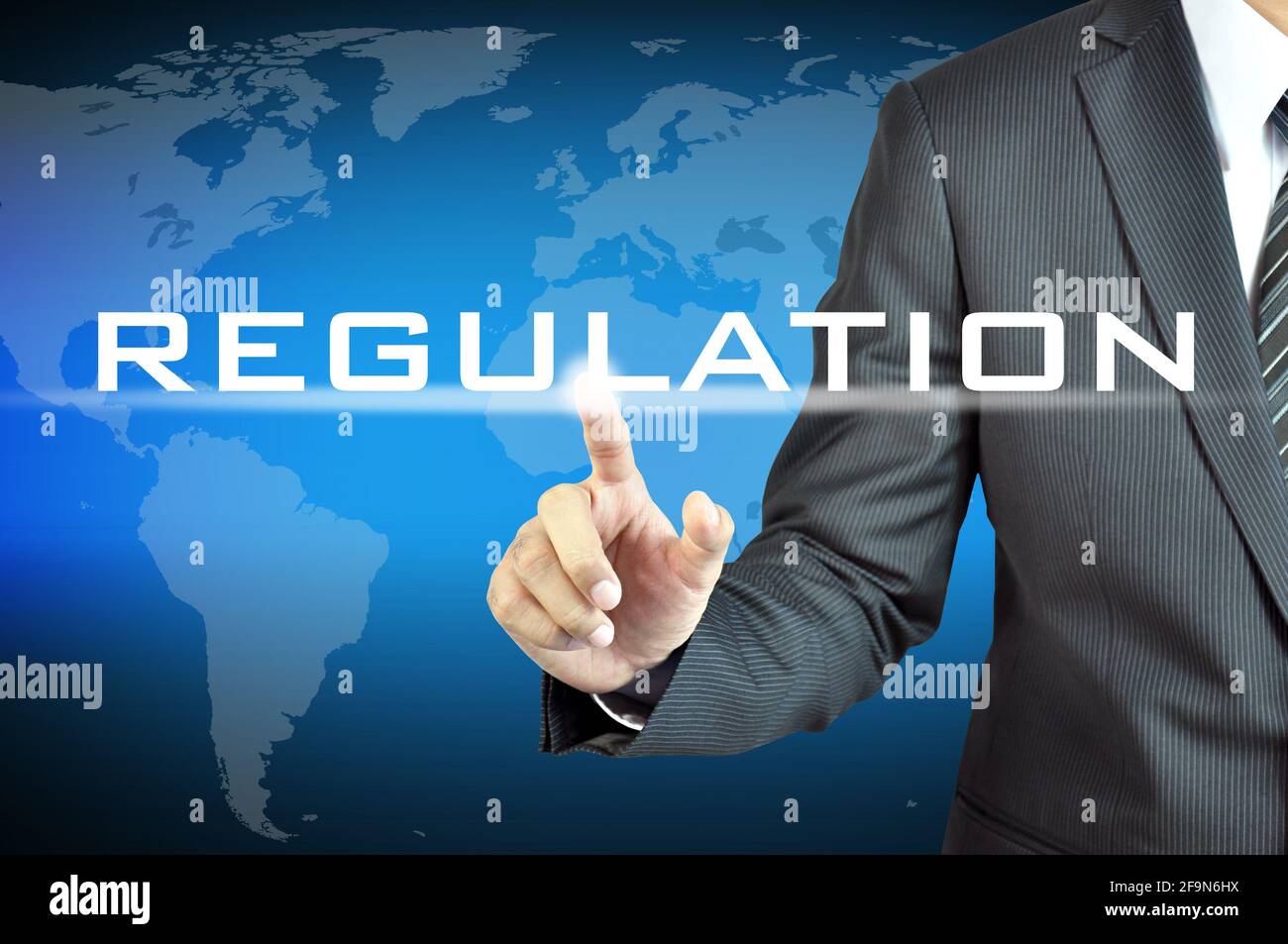 Businessman hand touching REGULATION sign on virtual screen - business ...
