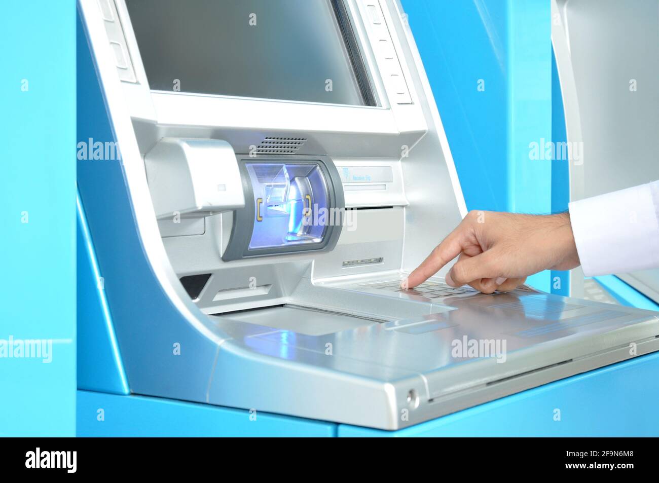 ATM (or Automated Teller Machine ) with hand pressing on the keypad ...