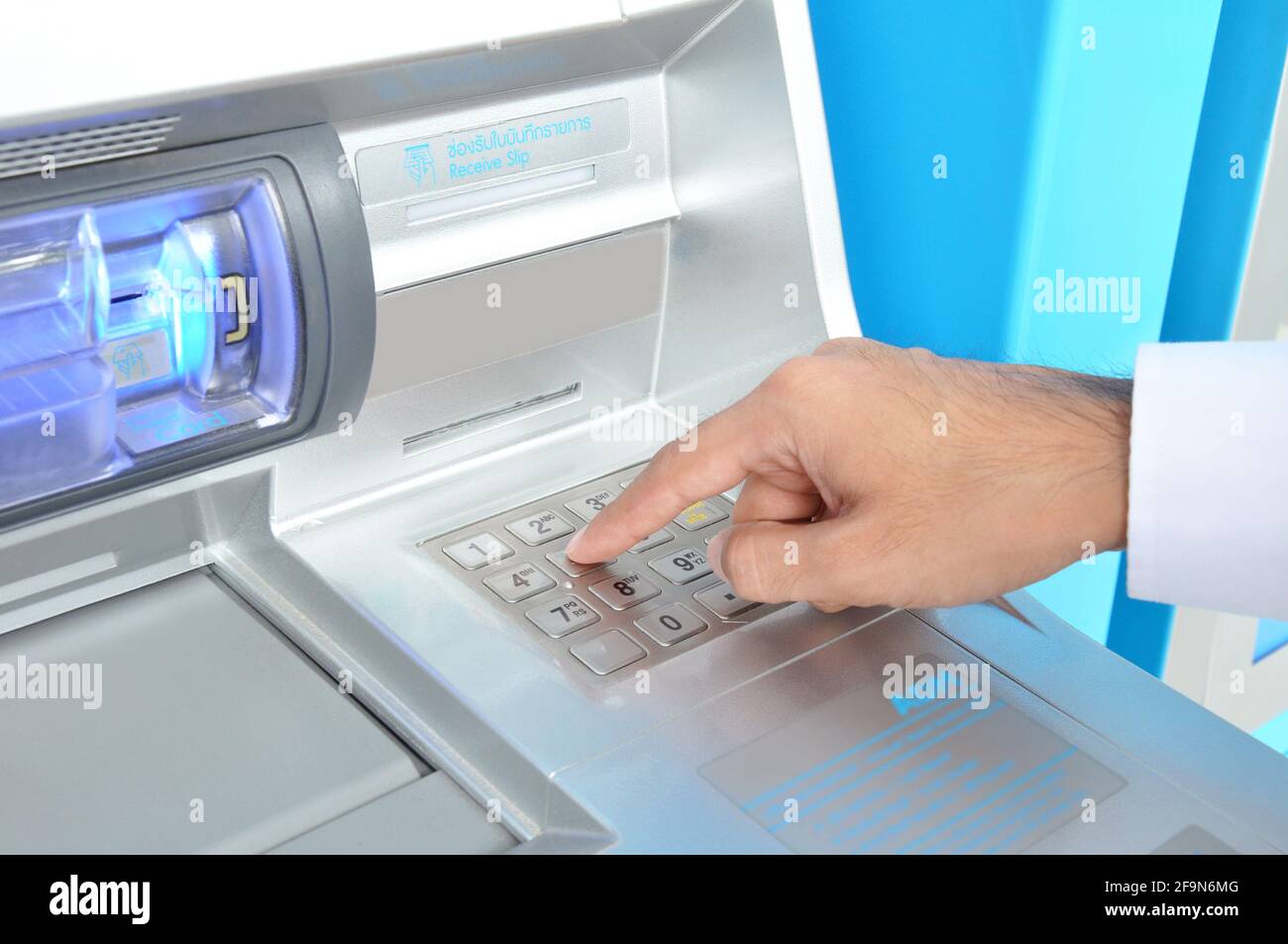 ATM (or Automated Teller Machine ) with hand pressing on the keypad ...