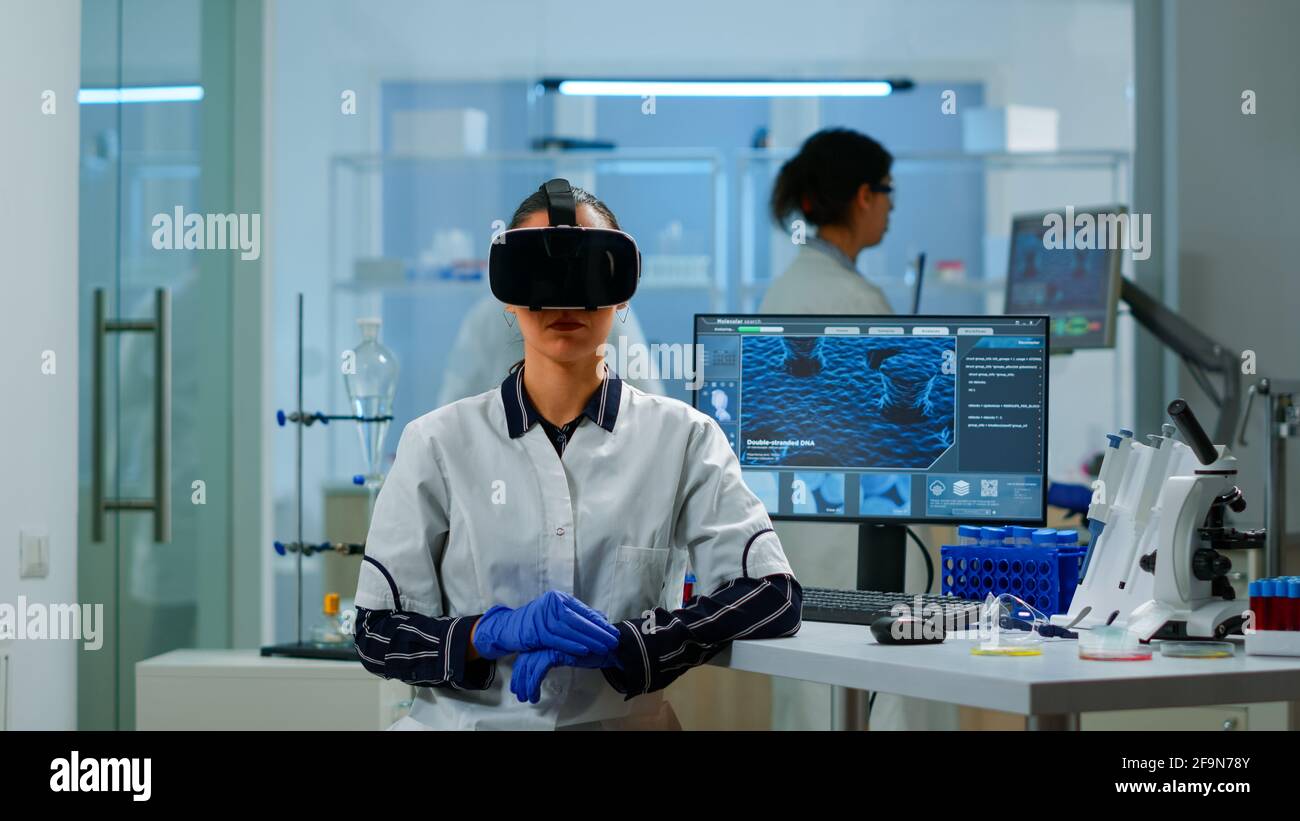 Laboratory doctor experiencing virtual reality using vr goggles in medical research lab ...