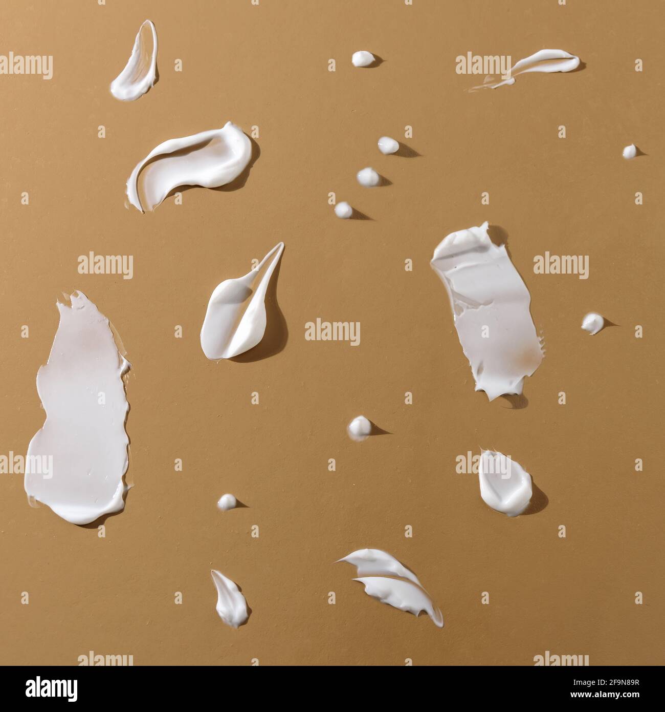Set of different white cream smears on brown Stock Photo - Alamy