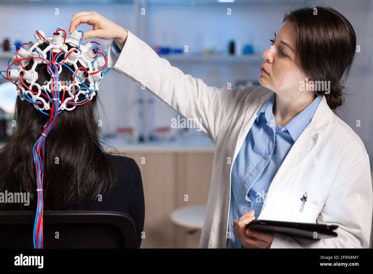 Back view of woman patient wearing performant eeg headset sitting on ...