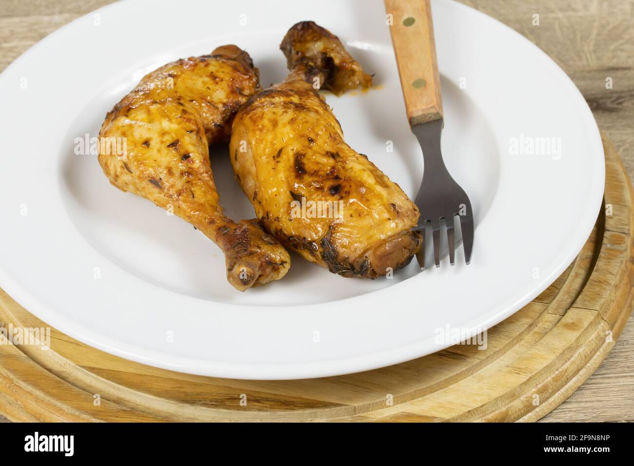 chicken leg cooked in a white plate Stock Photo - Alamy
