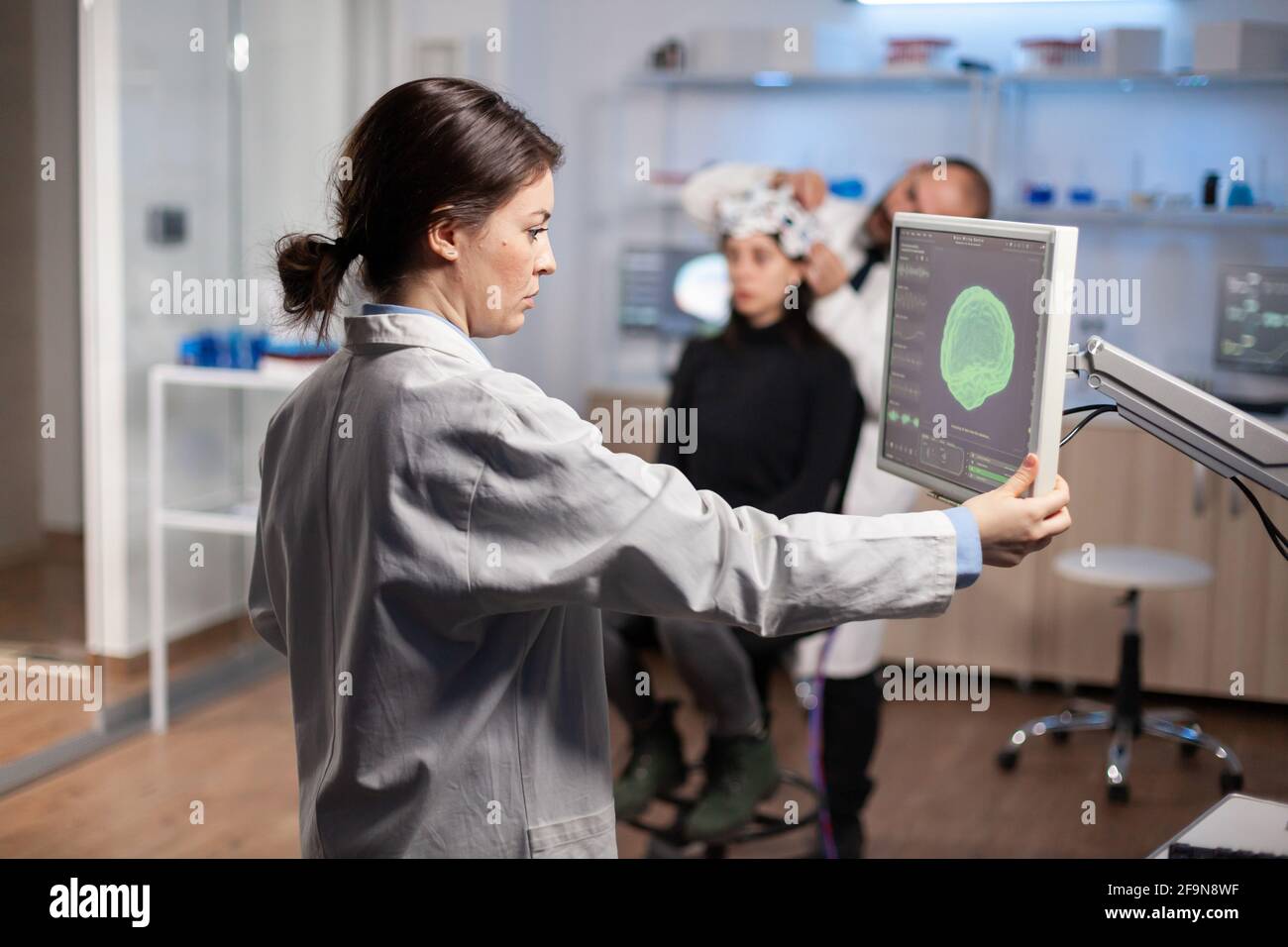 Neurologist doctor analysing brain scan on monitor display in modern ...