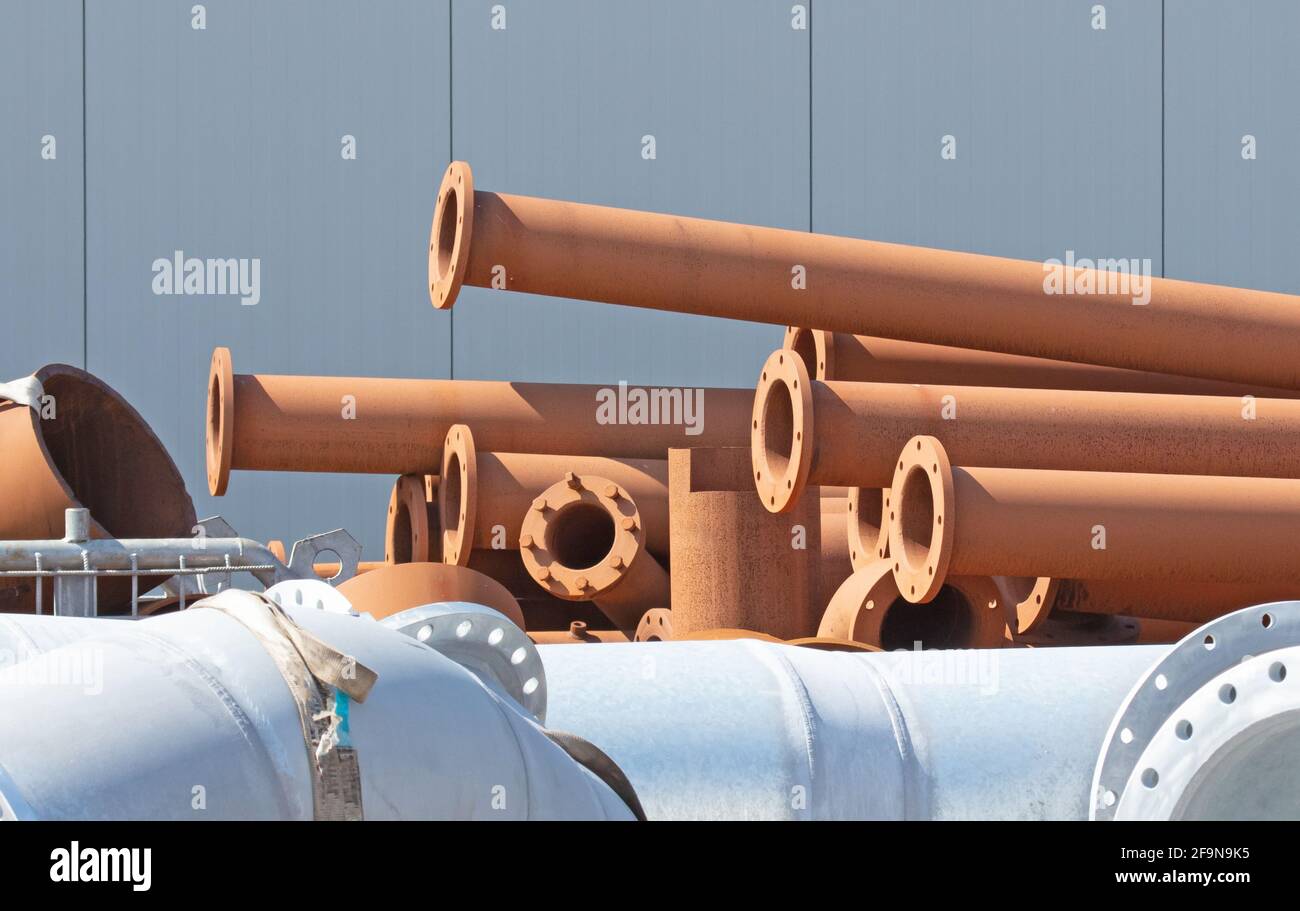 Large steel pipes on the ground, focus on the rusted pipes, ready to be ...