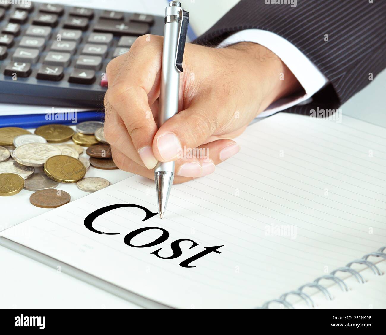 Hand with pen pointing to Cost word on the paper - financial & business ...
