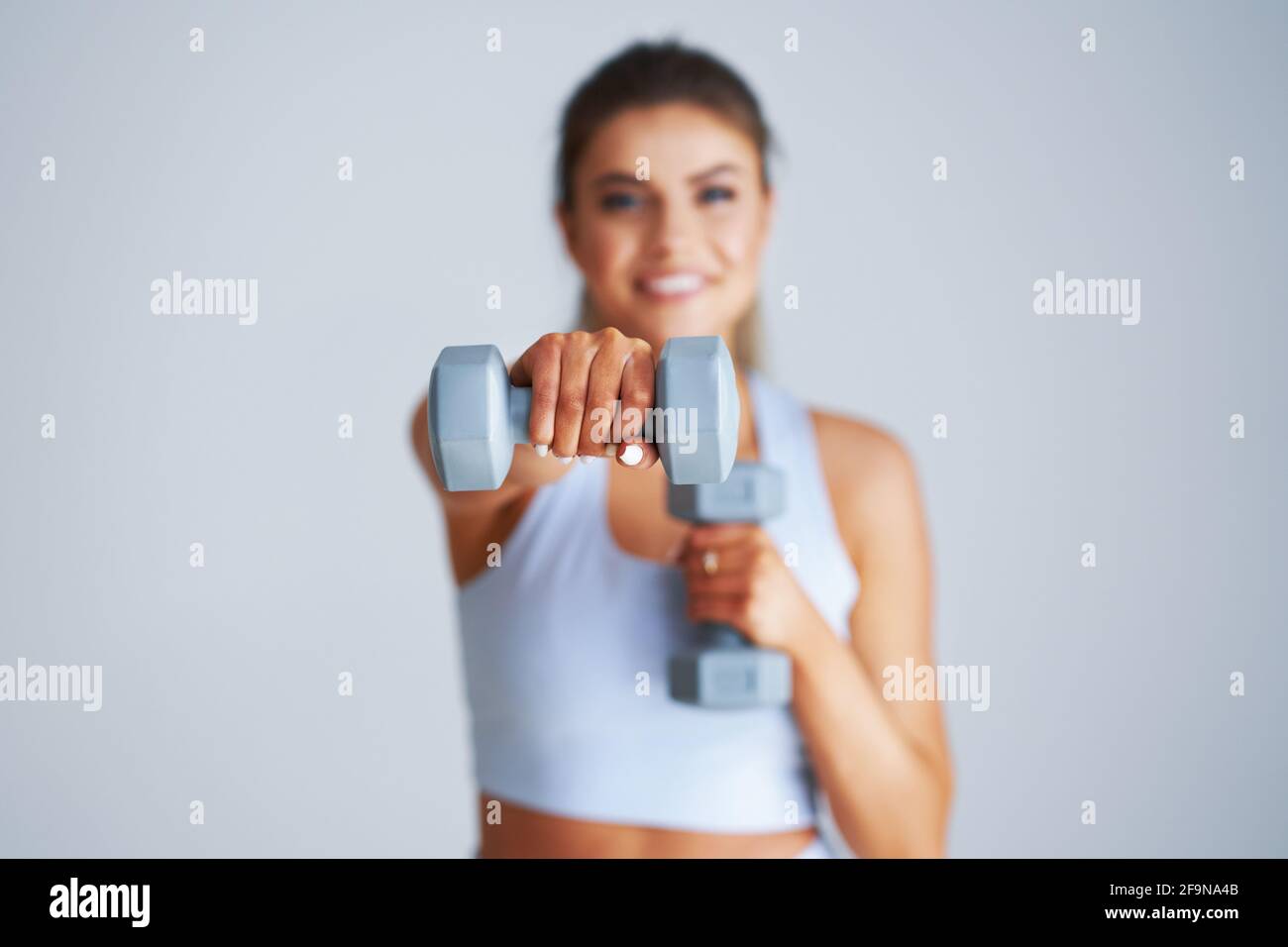 Adult beautiful woman working out over light background Stock Photo - Alamy