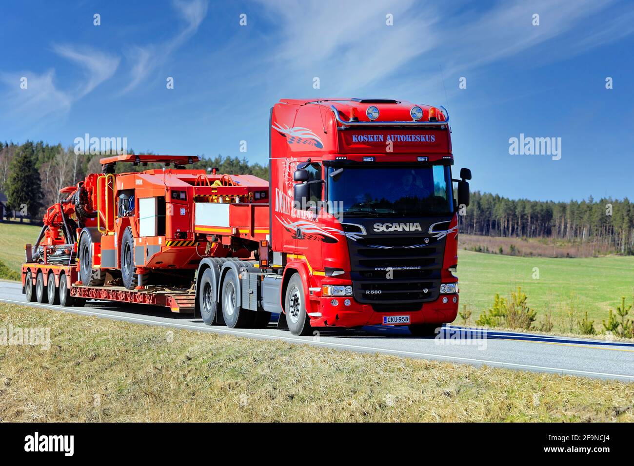 Red Scania R580 semi trailer truck transports Sandvik mining equipment ...