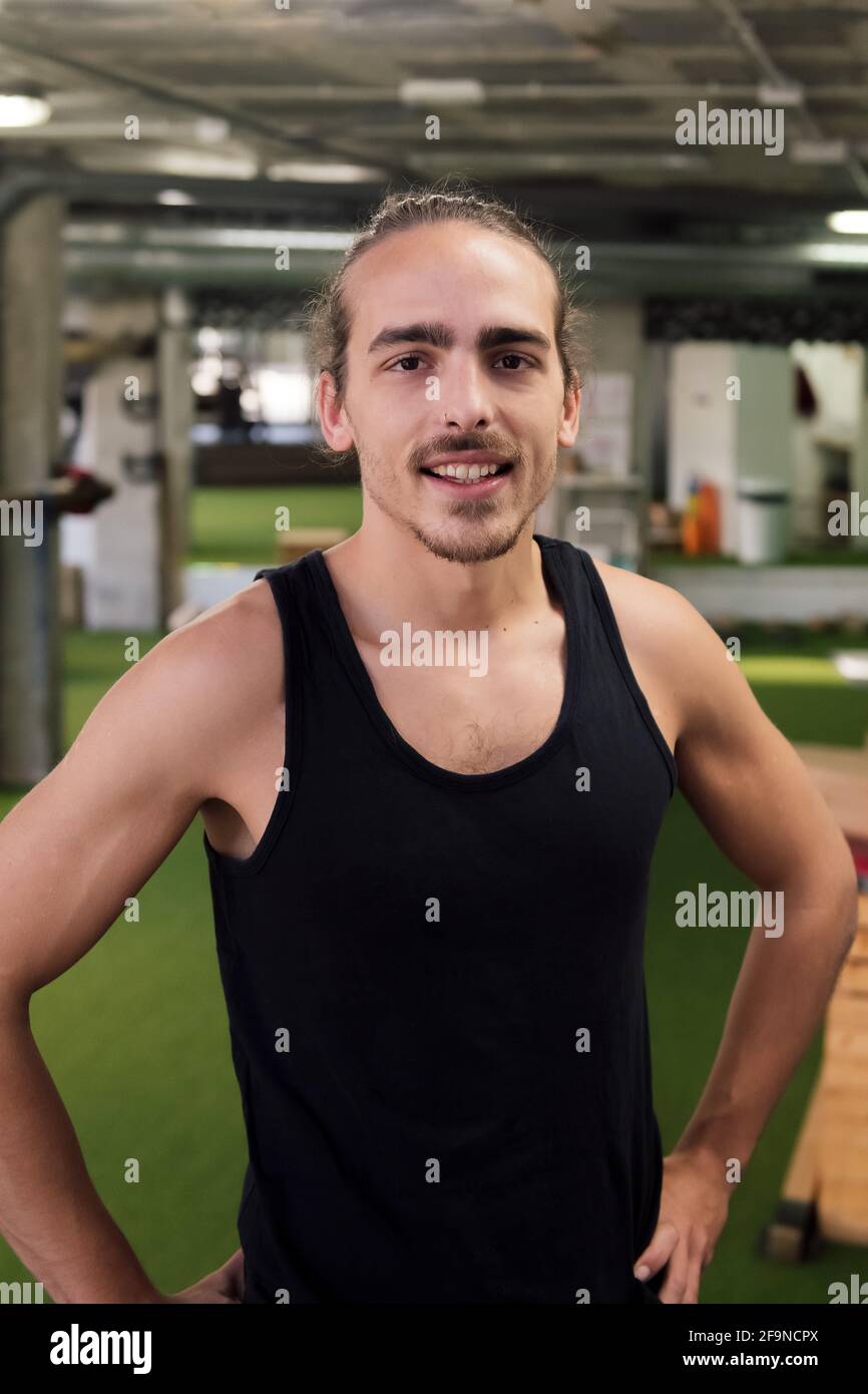 vertical portrait of a young trainer posing in his gym, concept of ...