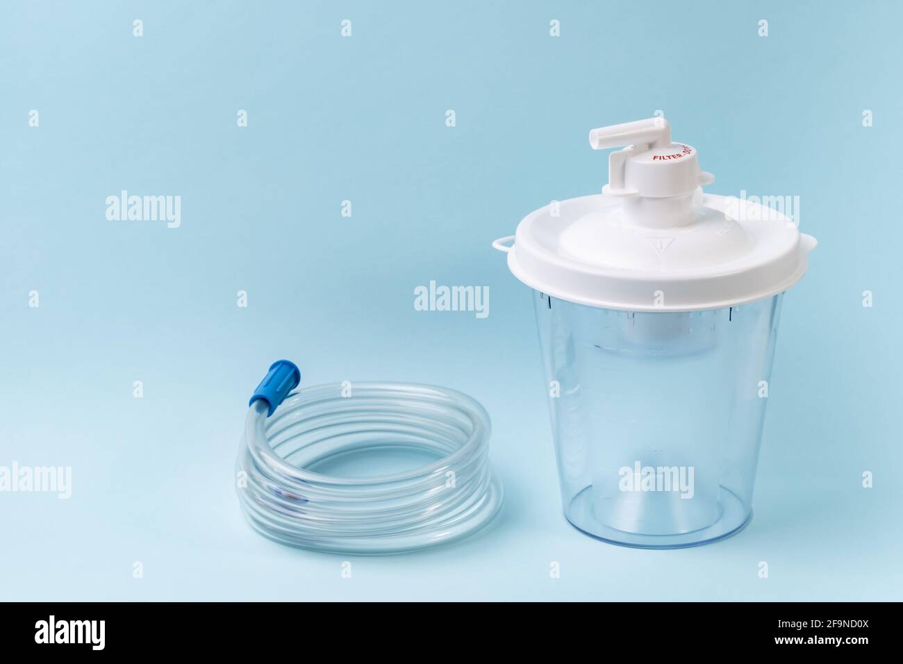 Plastic canister from medical suction machine on blue backdrop Stock ...