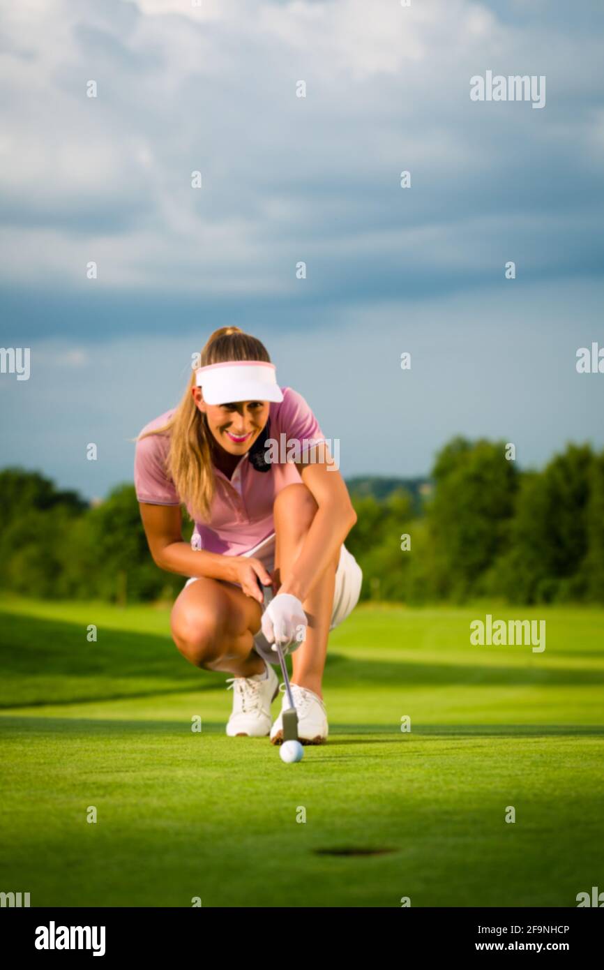 Young female golf player on course aiming for put Stock Photo - Alamy