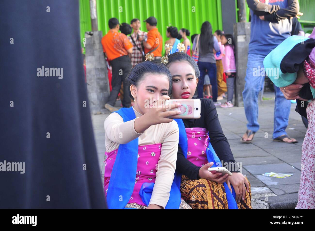two Javanese girls wearing traditional outfit taking a selfie photo ...
