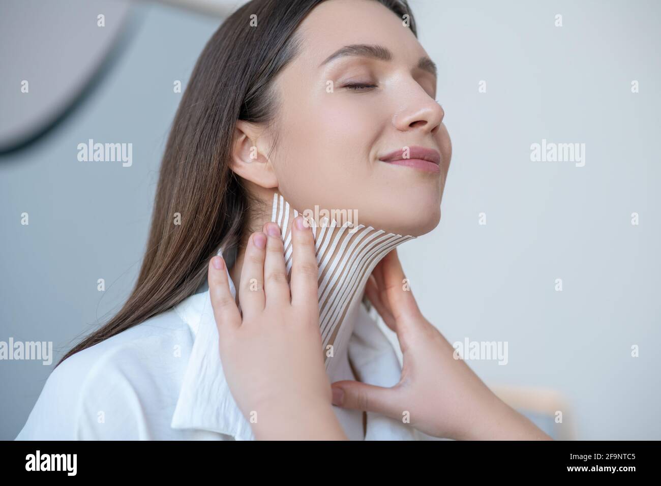 Woman taping neck hi-res stock photography and images - Alamy