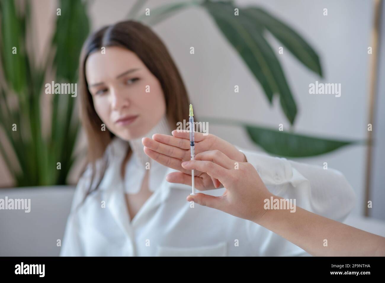 Cute young woman visiting beauty center and rejectong botox injections ...