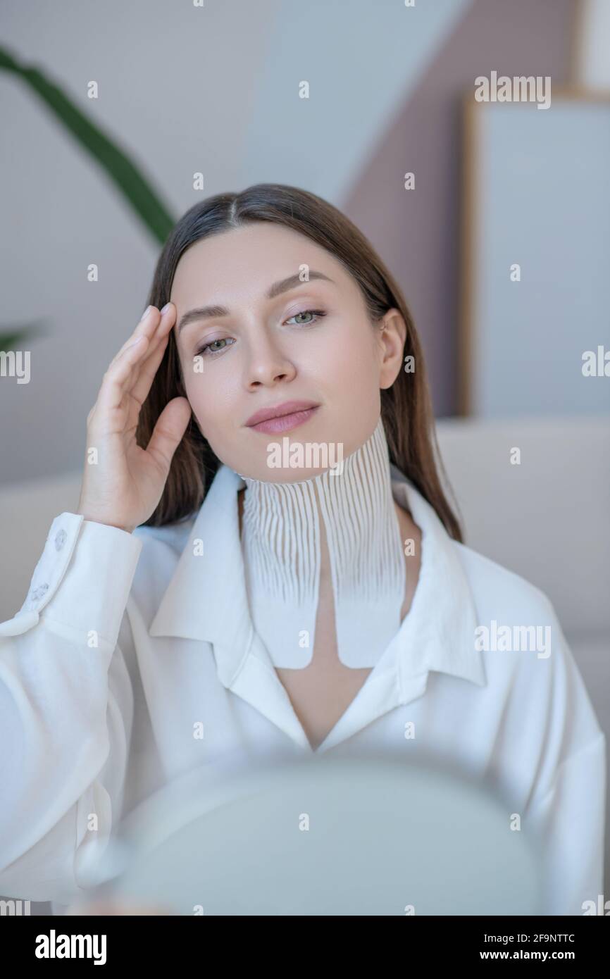 Cute young woman doing face massage and looking relaxed Stock Photo - Alamy