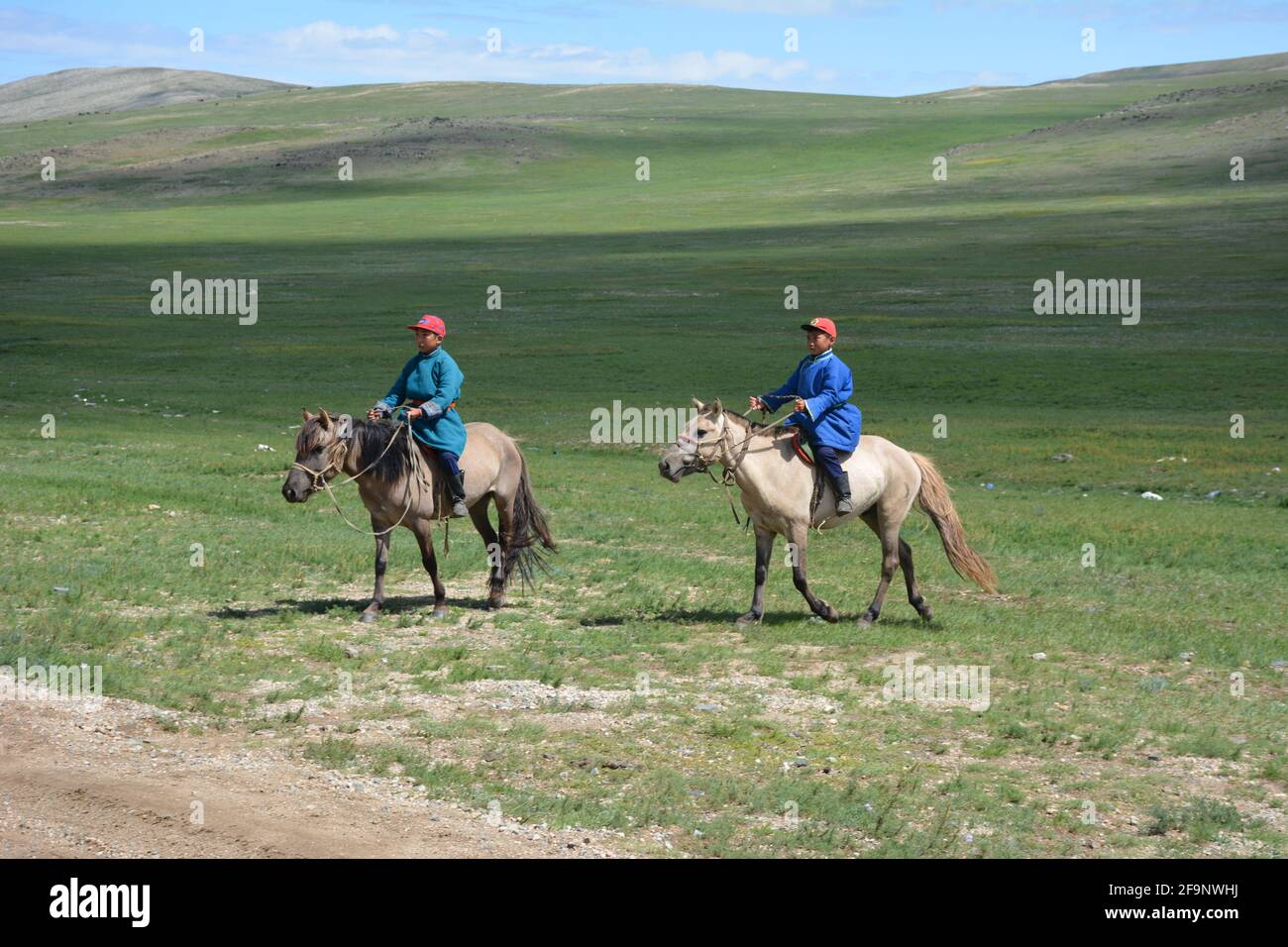 Child nomadic herders in traditional dress on horseback on the steppes ...