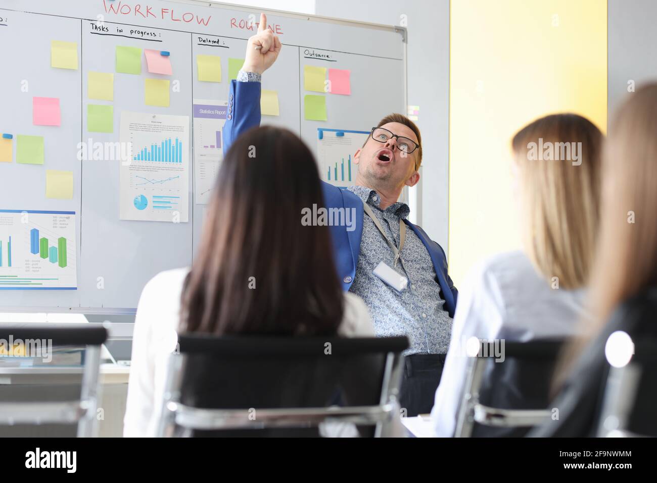 Successful businessman showing finger up at conference in front of ...