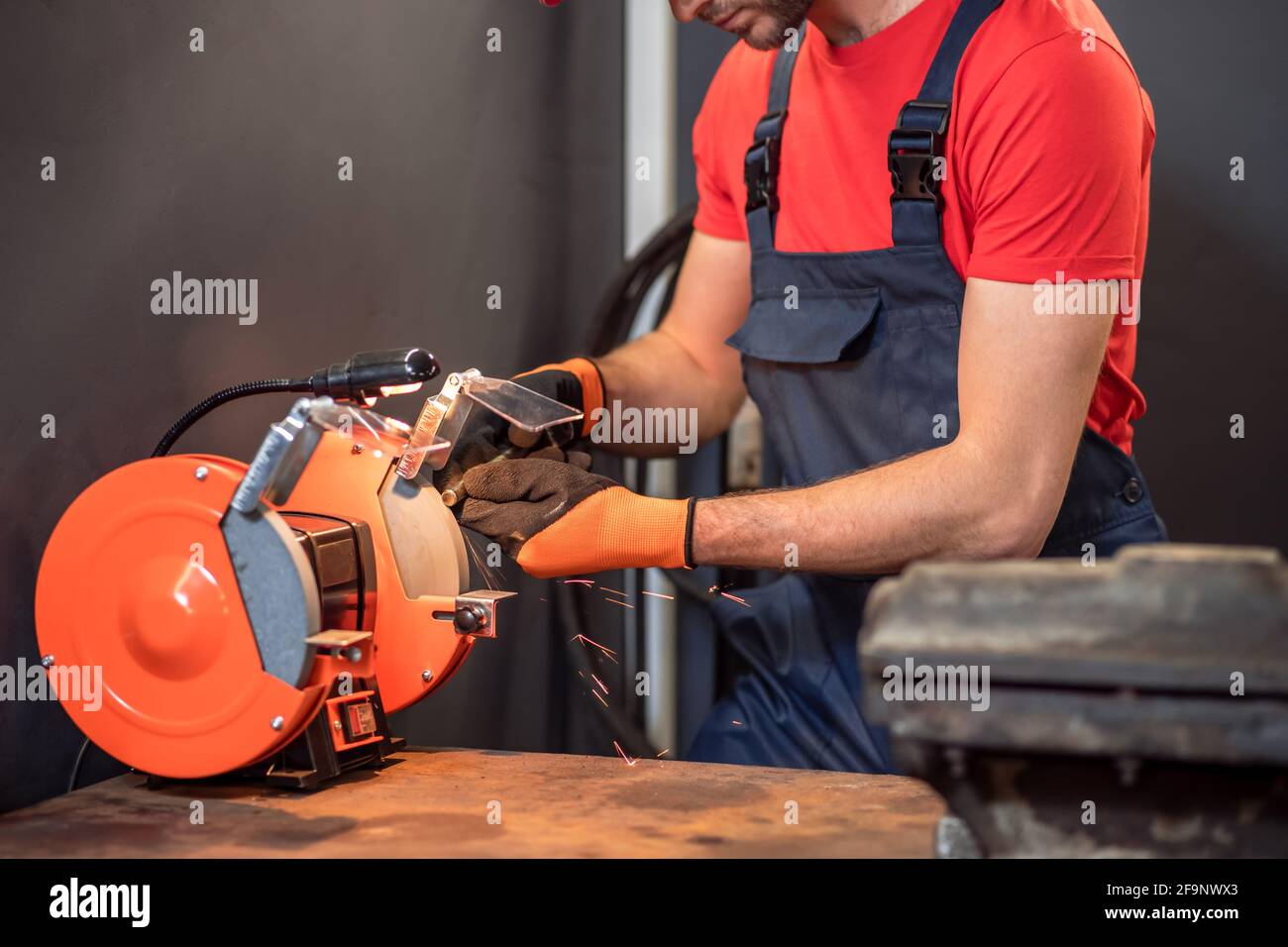 Male hands holding part near grinding machine Stock Photo - Alamy