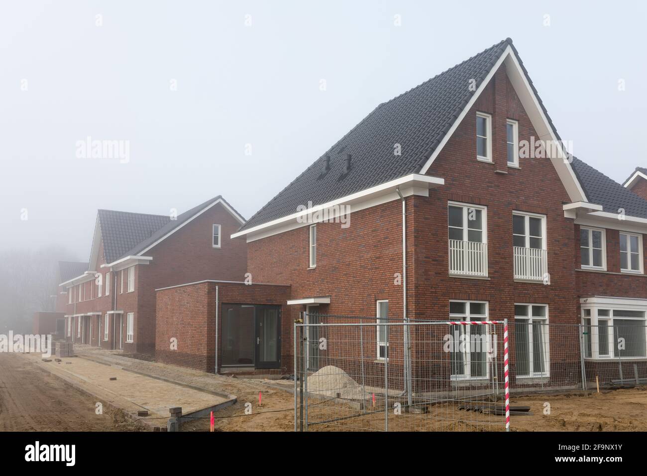 Almost finished new built houses in the mist at construction site in ...