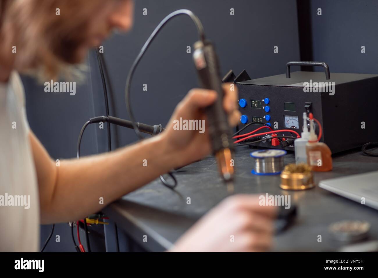 Hands of man with special device in workshop Stock Photo - Alamy