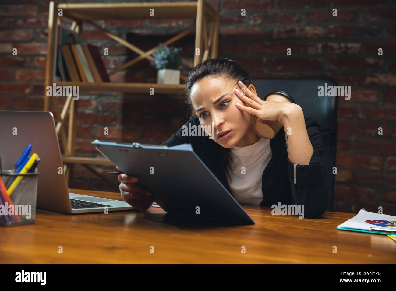 Young woman working in modern office using devices and gadgets. Making ...