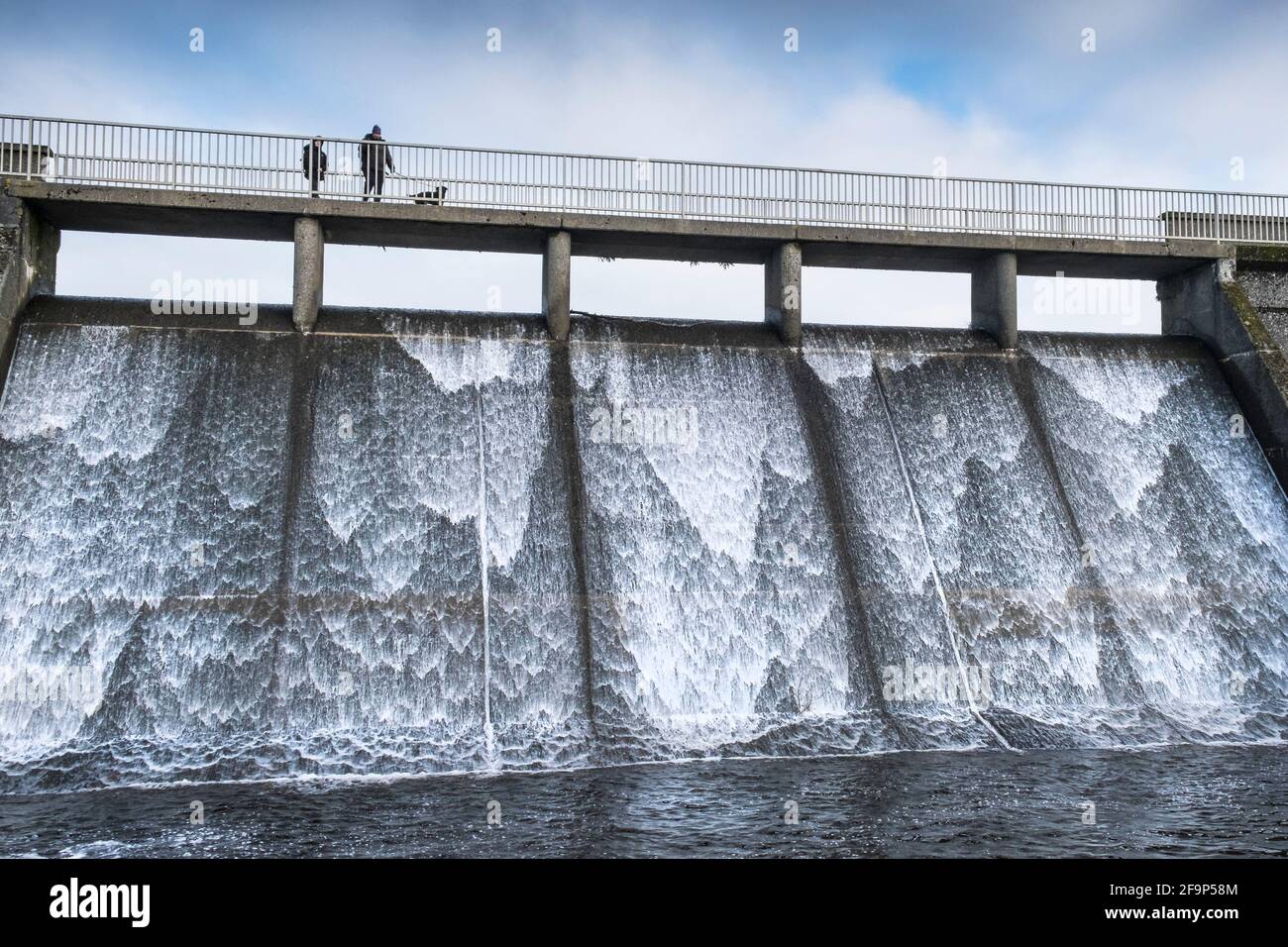 People on the walkway above the overflow spillway of Crowdy Reservoir ...