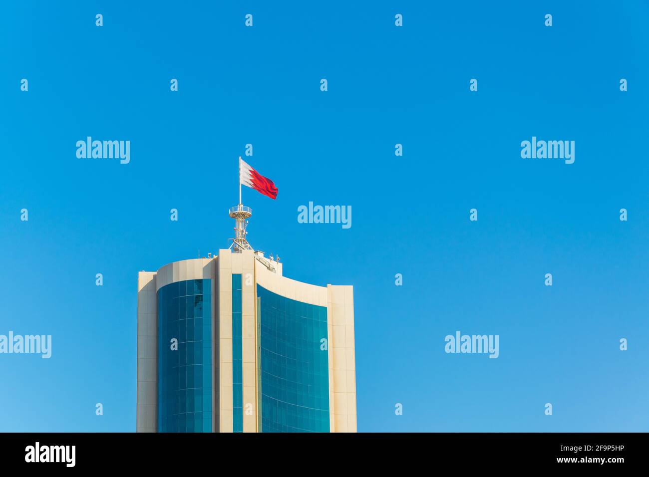 Flag of Bahrain is waving on top of a skyscraper in Manama Stock Photo ...