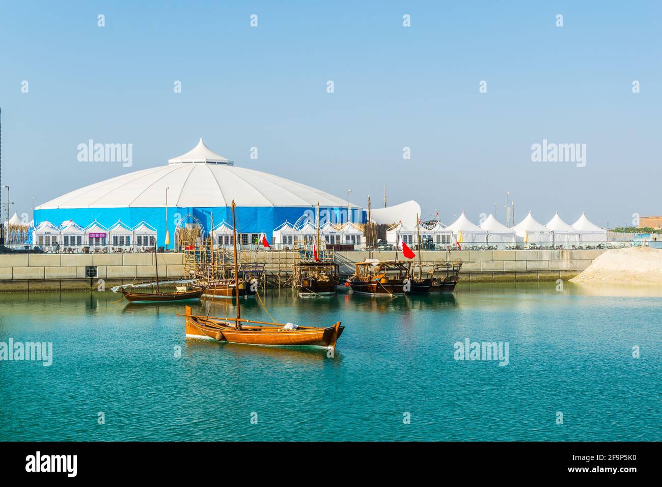 A group of dhows, traditional boats of Bahrain, are anchoring in front ...