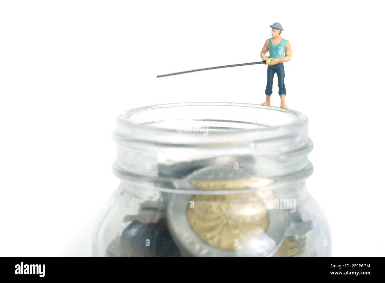 Miniature people toy photography. An angler standing above money jar ...
