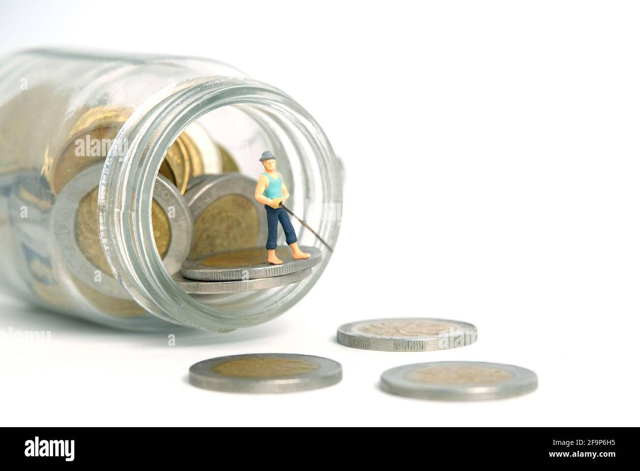 Miniature people toy photography. An angler standing above money jar ...