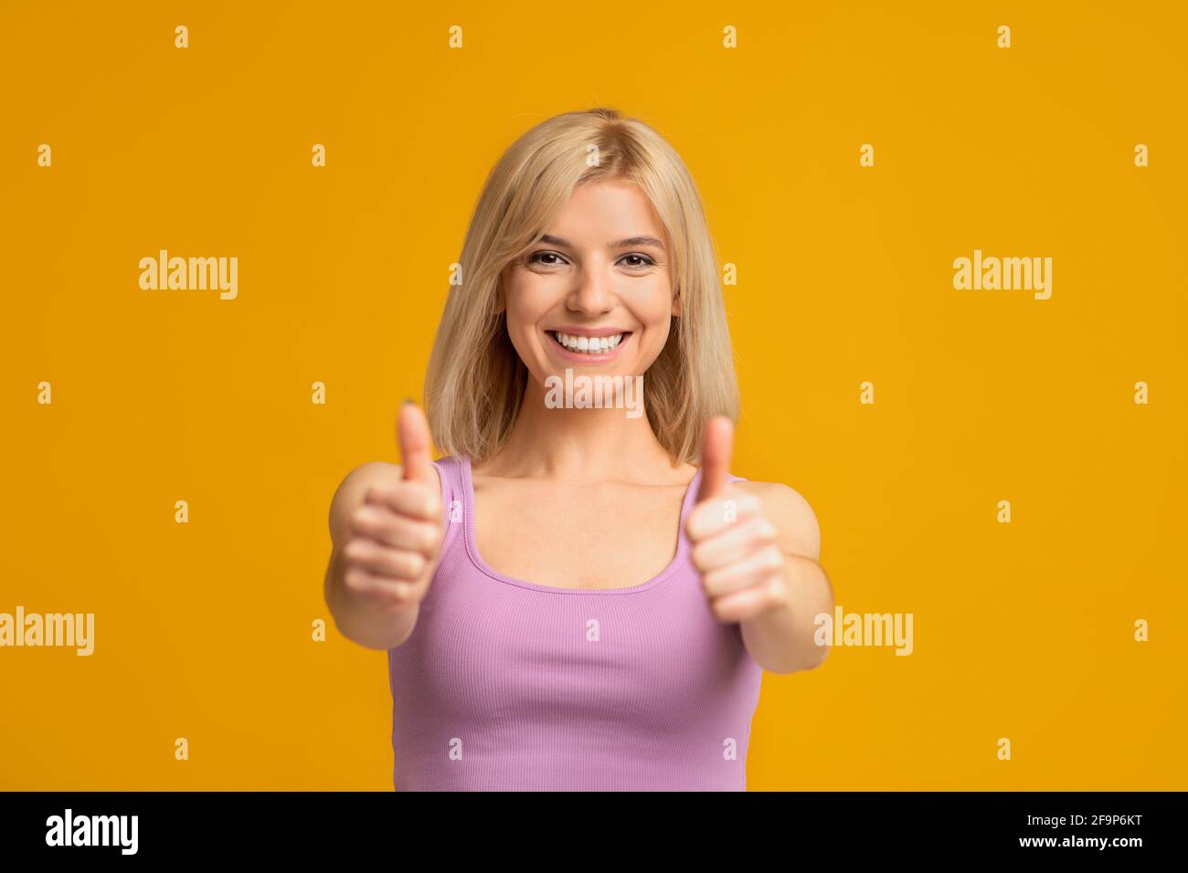 Everything is fine. Happy lady making thumb up gesture, recommending ...