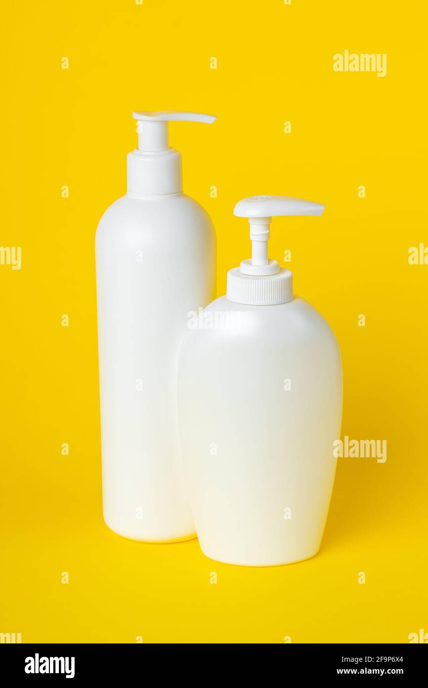 Two plastic bottles on yellow background, set of cosmetic containers ...